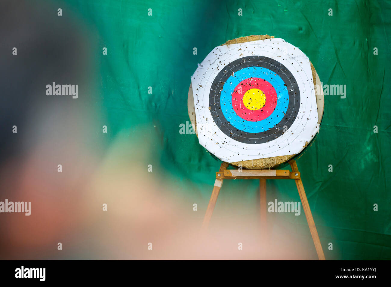 Archery target ring and out of focus archer with a bow in the ...