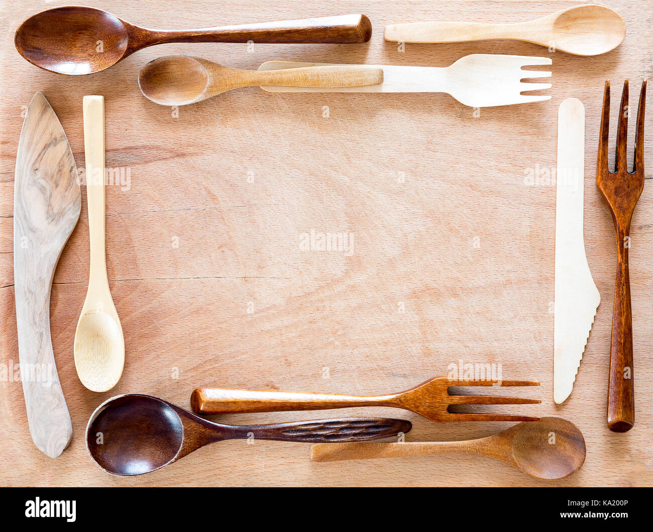 Wooden kitchenware frame on a wooden background from above. Studio shot ...