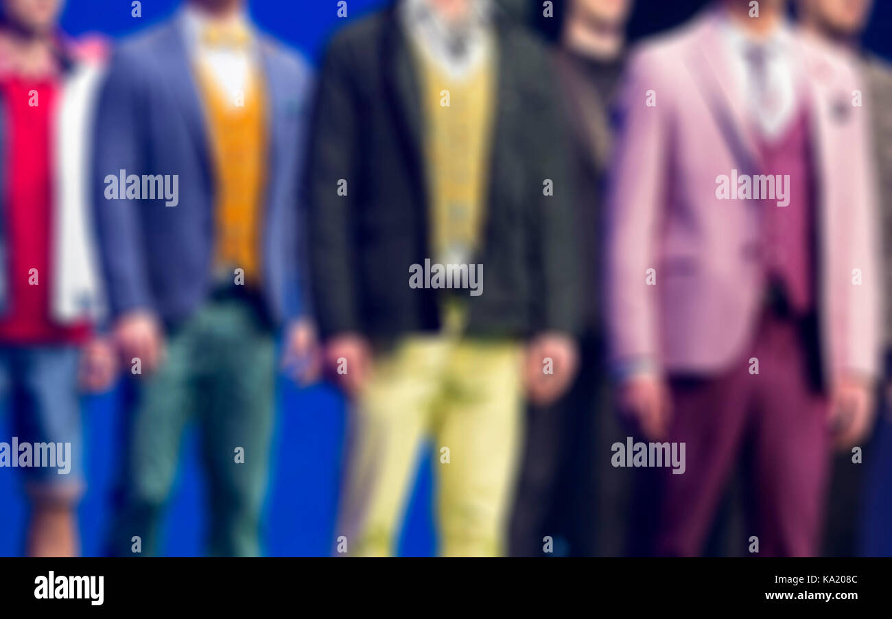 Blurry out of focus (defocus) Male models walk the runway in different ...