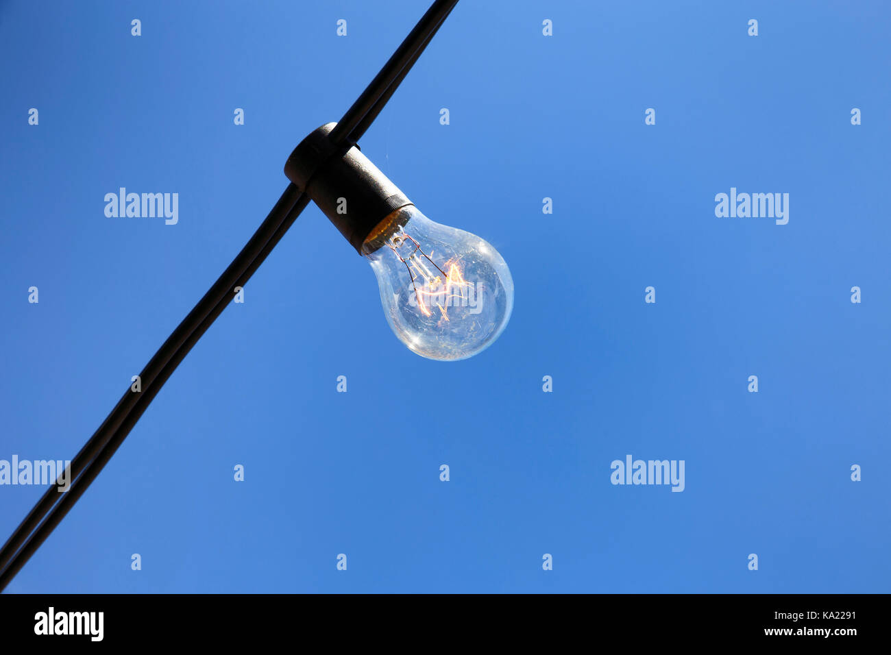 single light bulb on sky background hanging of a wire Stock Photo - Alamy