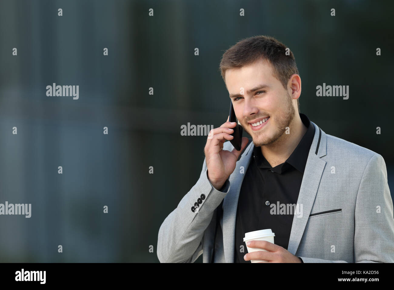 Single executive talking in a phone call walking on the street with an ...