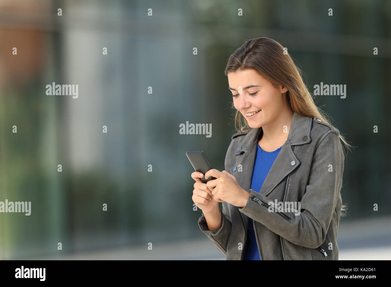 Single fashion teen using a smart phone walking on the street Stock ...