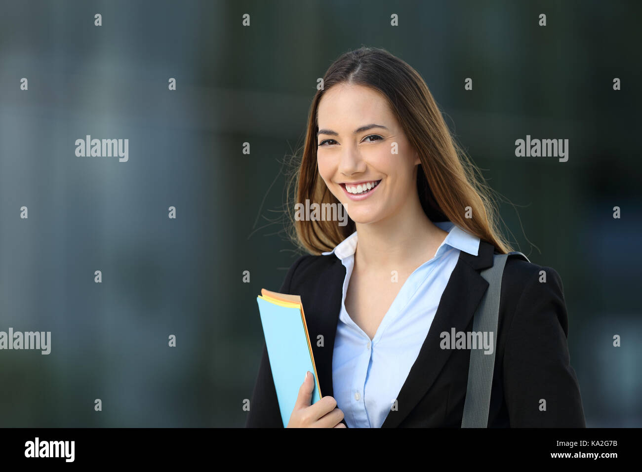 Happy executive posing looking at you standing alone on the street ...