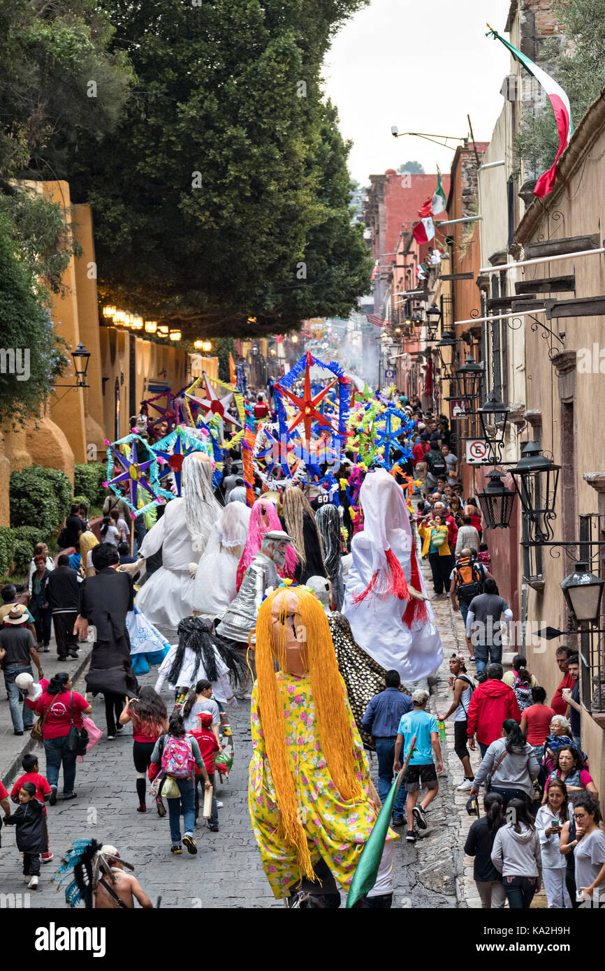 Giant paper mache puppets in a fiesta procession through the city at ...