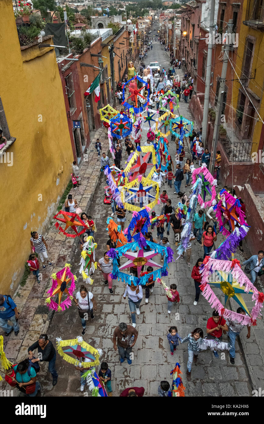 Colorful paper stars march in a fiesta procession through the city at ...