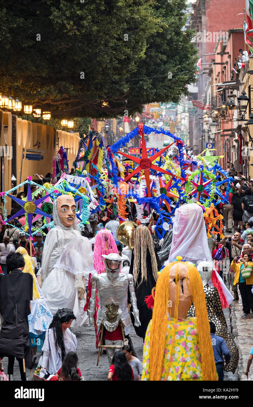 Giant paper mache puppets in a fiesta procession through the city at ...