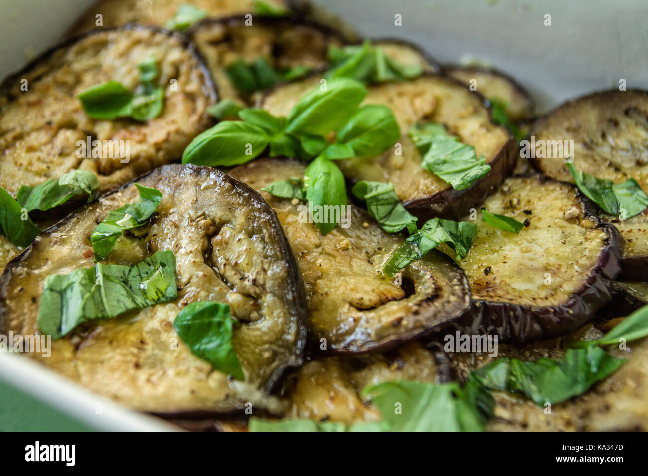 Fried and cooked aubergine with garlic basil in olive oil Stock Photo ...