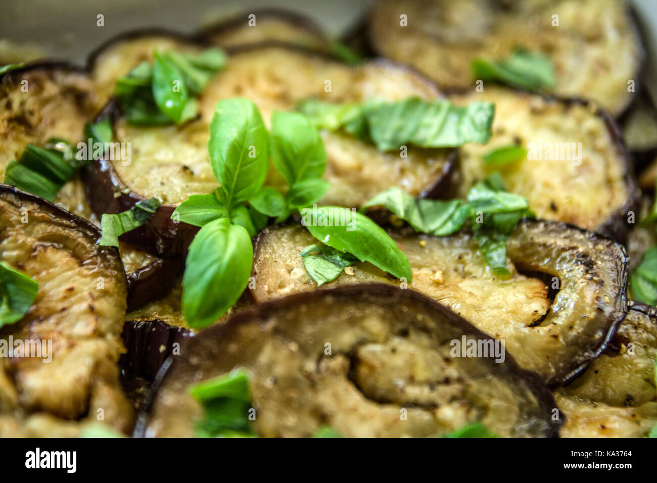 Fried and cooked aubergine with garlic basil in olive oil Stock Photo ...