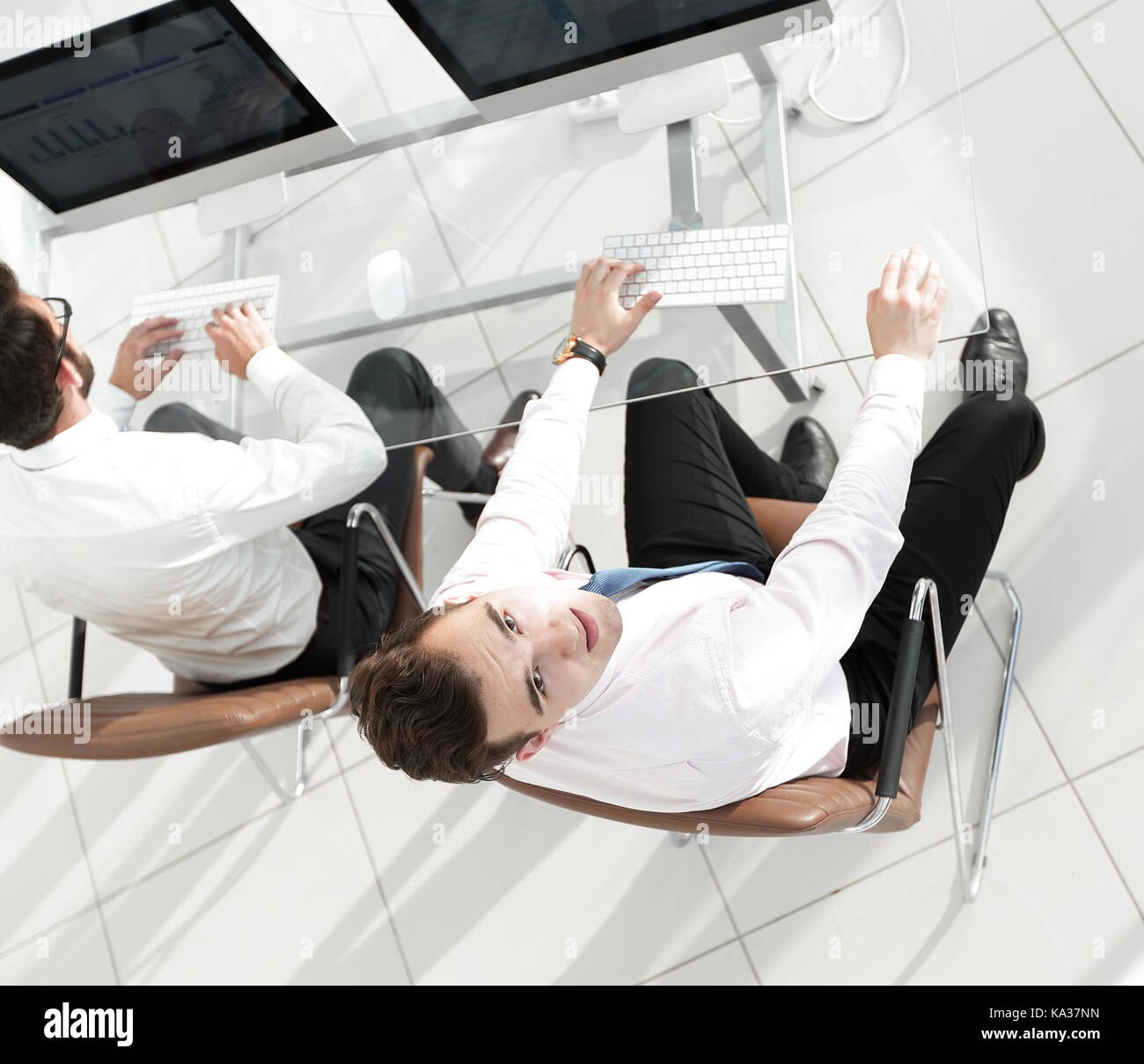 office life.employees sitting behind a Desk Stock Photo - Alamy