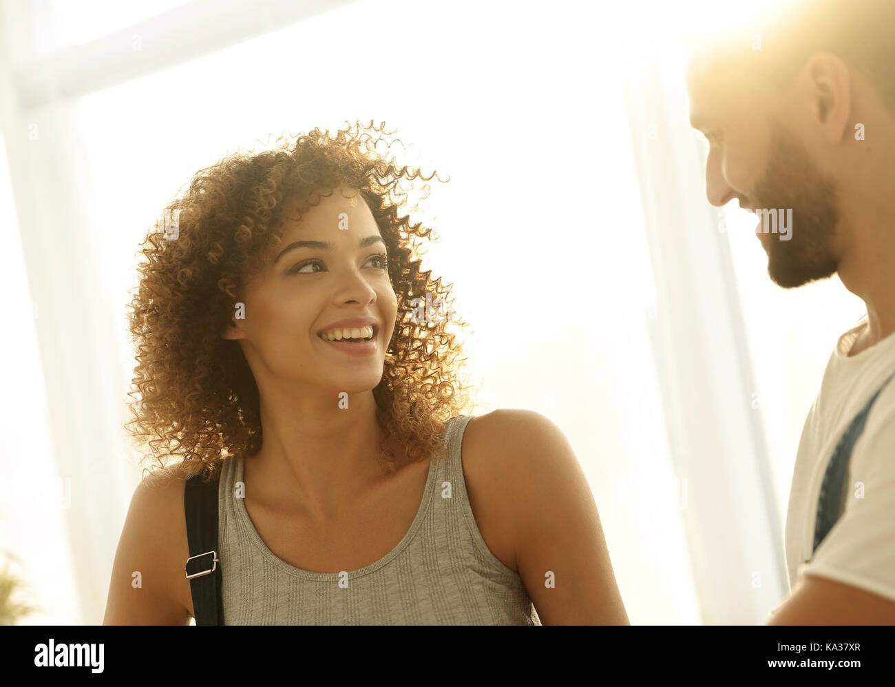 Happy couple standing near the window Stock Photo - Alamy