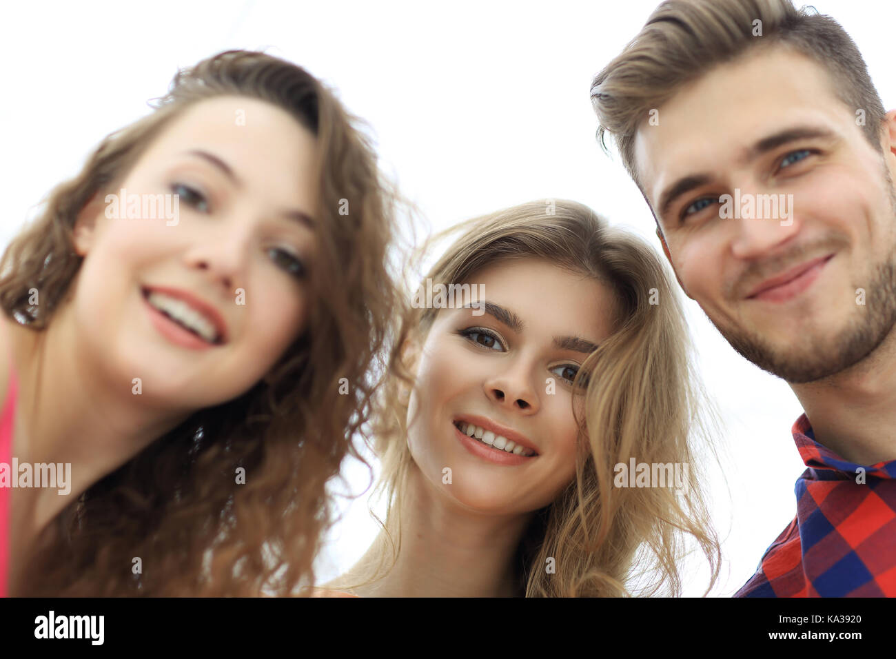 closeup of three young people smiling on white background Stock Photo ...