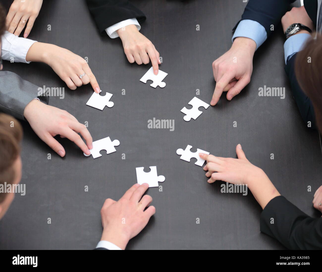 puzzle pieces in the hands of the business team Stock Photo - Alamy