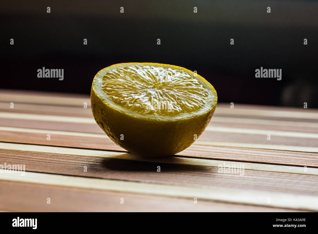 Lemon on the wooden table with dark background Stock Photo - Alamy