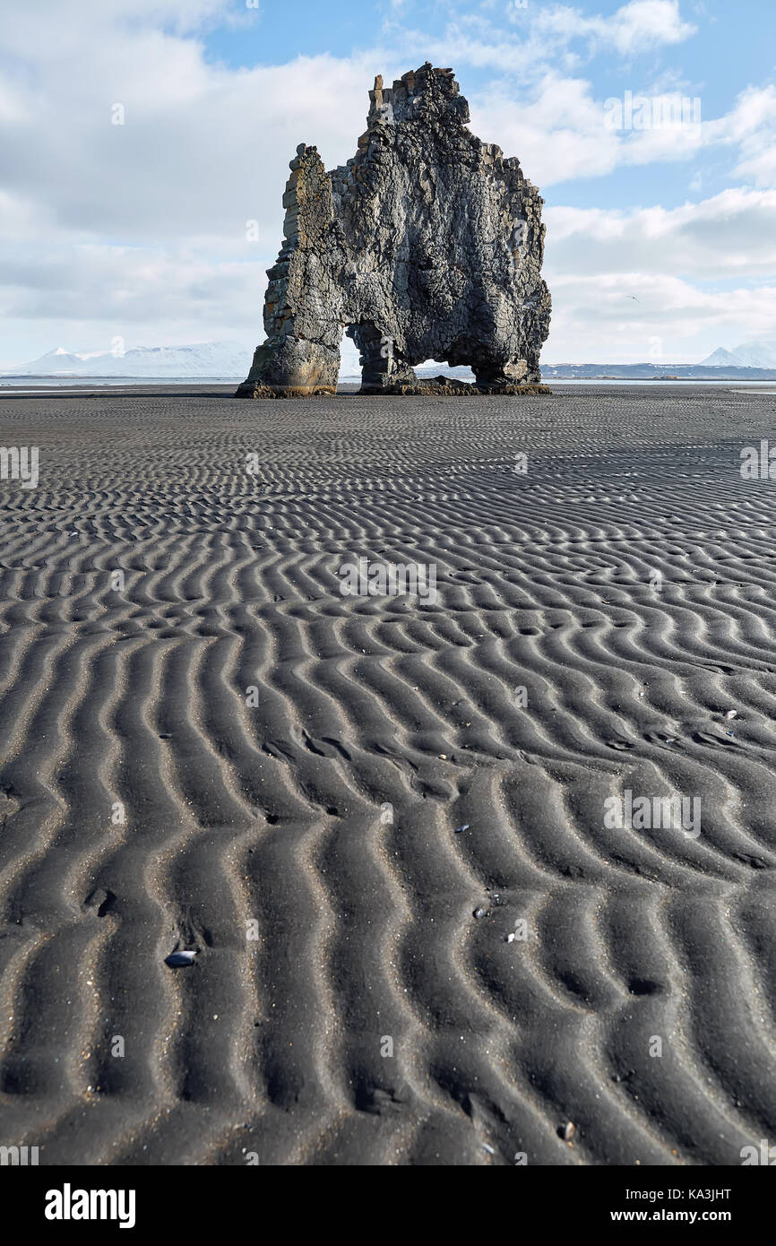Big stone formation on the dark volcanic sand on the background of the ...
