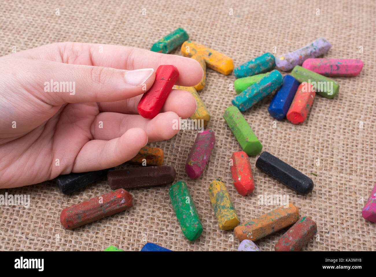 Used color crayons and a hand holding one Stock Photo - Alamy