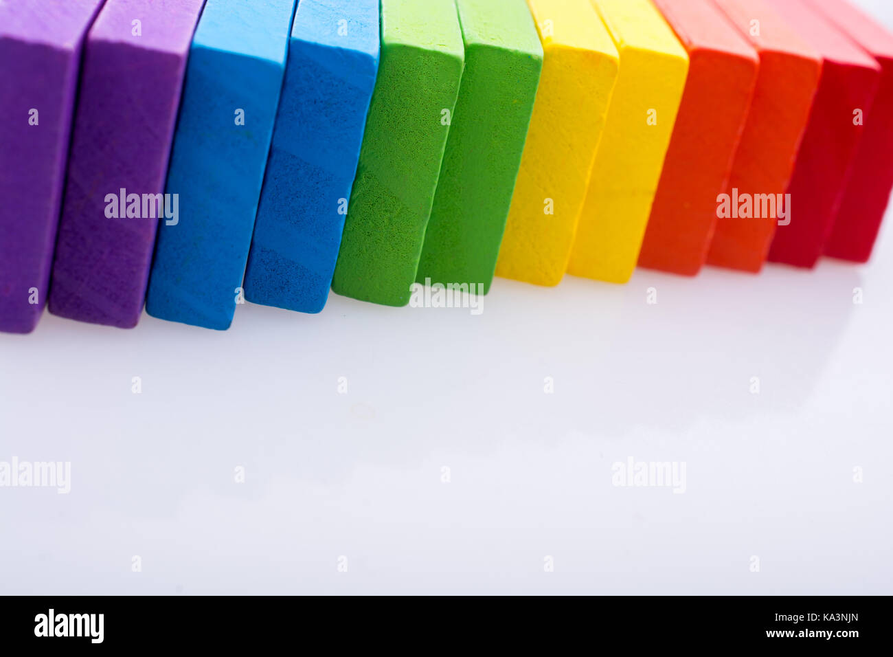 Colorful Domino Blocks in a line on a white background Stock Photo - Alamy