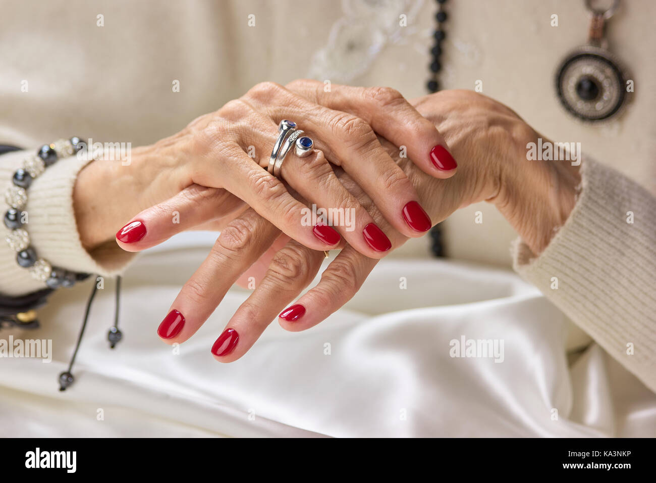 Luxury female hands with red manicure. Aged woman manicured hands with ...