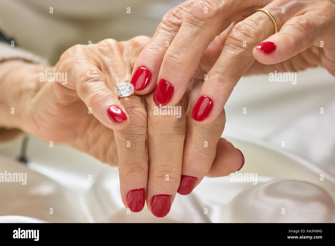 Female manicured hands with diamond. Senior woman hands with red nails ...
