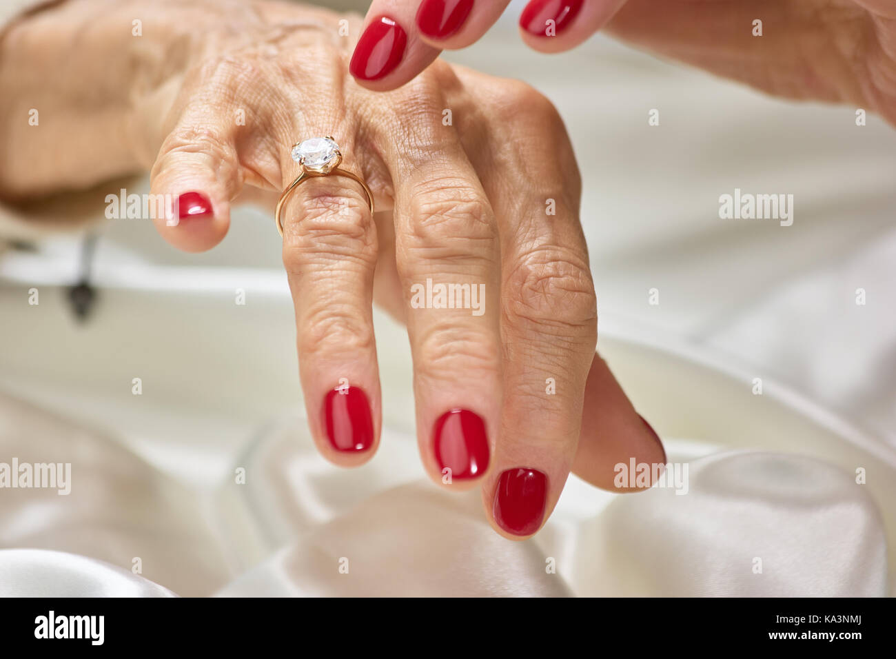 Female finger indicating on diamond. Senior woman with red nails ...