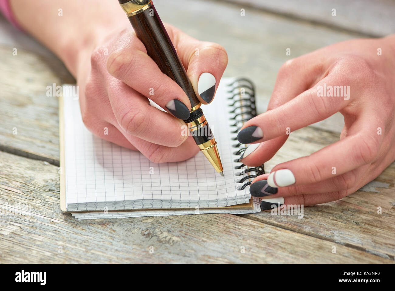 Woman with manicured hand writing on notebook. Female hand with modern ...