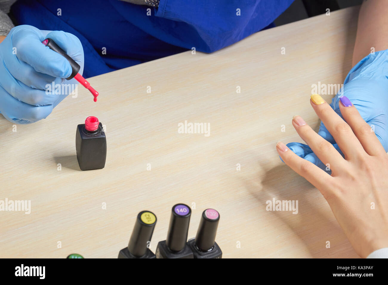 Woman having nail manicure in beauty salon. Manicurist holding hands of ...