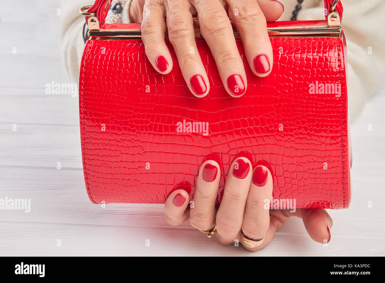 Elegant red handbag in female hands. Elderly woman hands with red ...