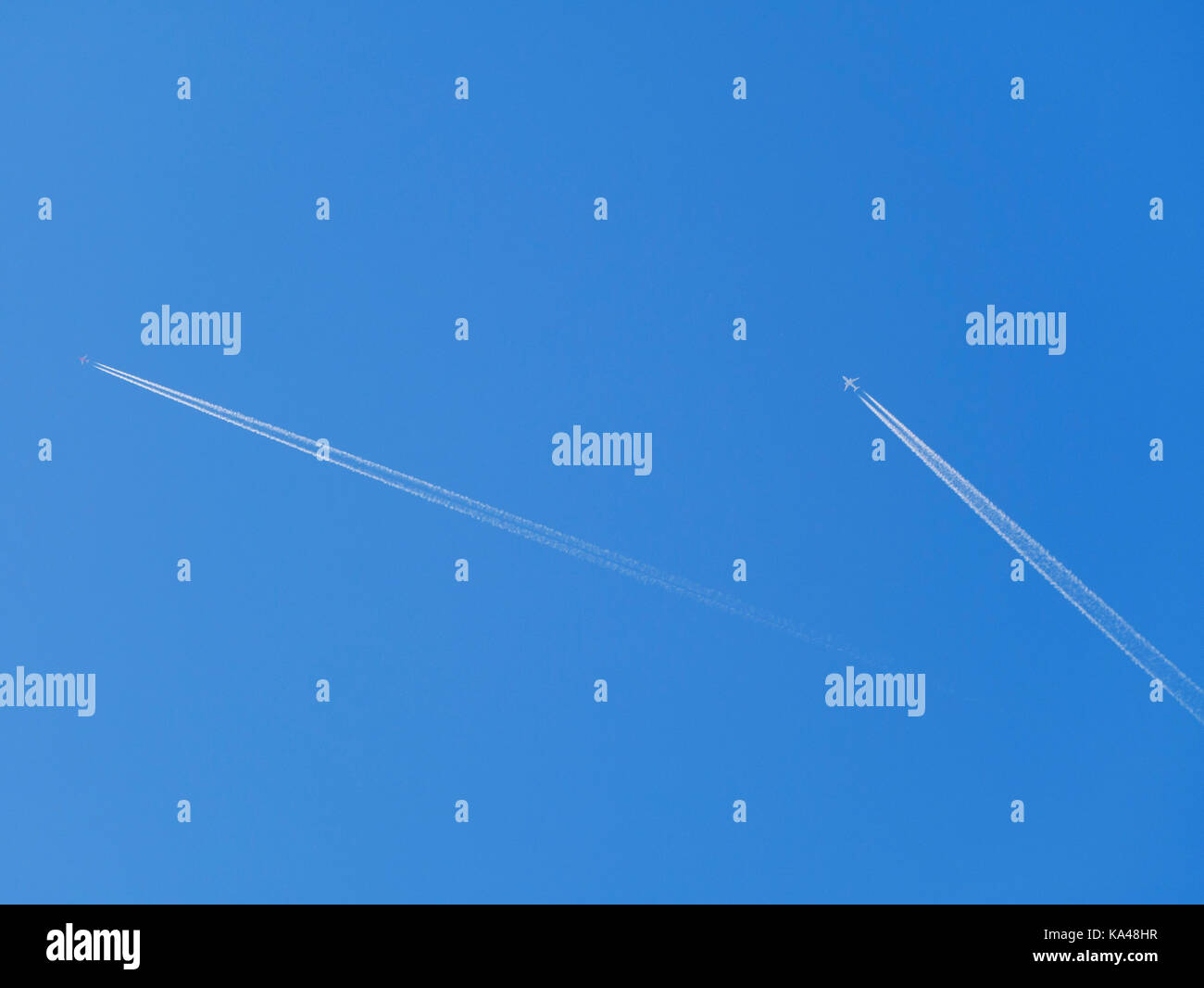 Two commercial jet aircraft with contrails at altitude Stock Photo - Alamy