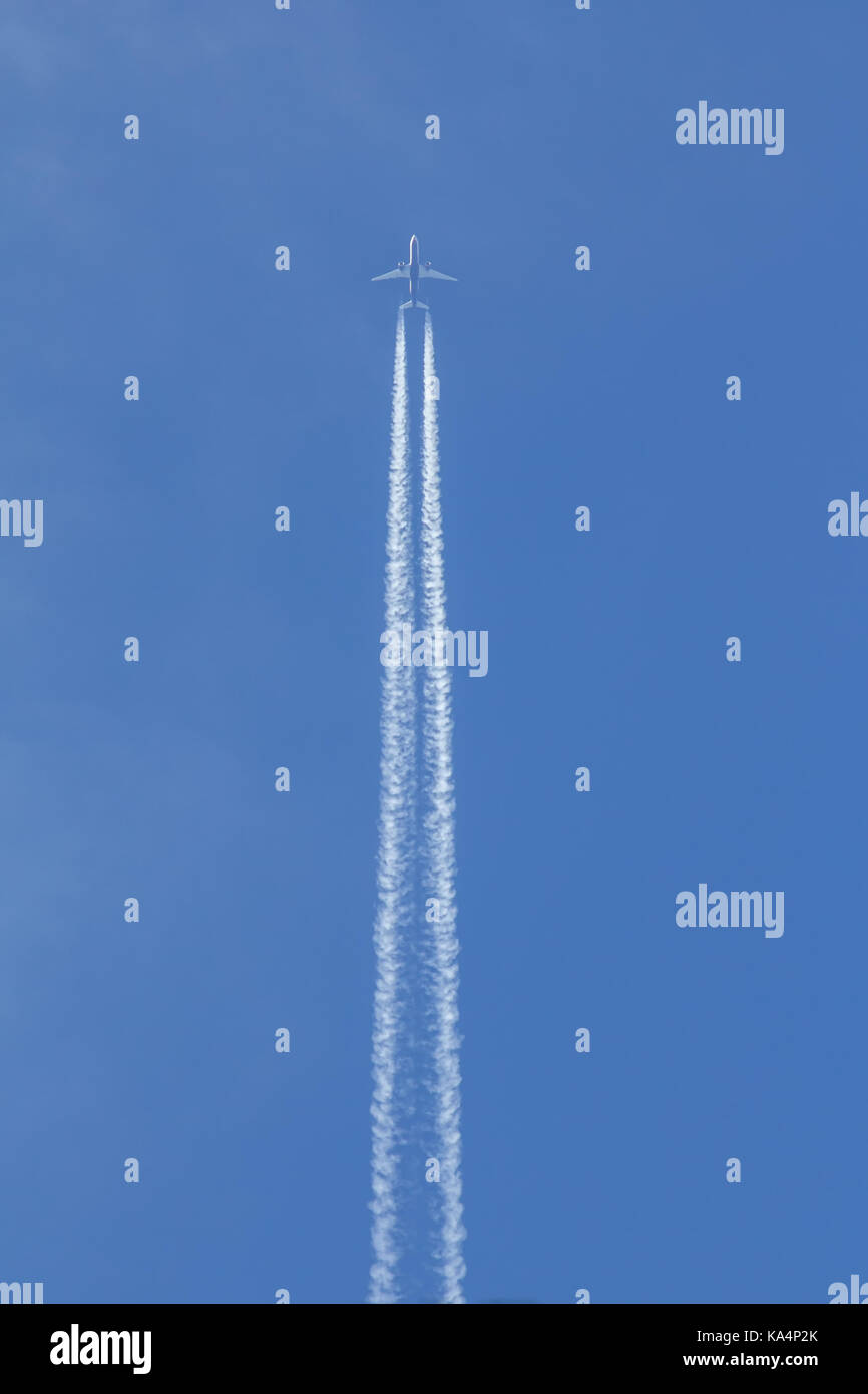 Jet is flying in the blue sky, vertical Stock Photo - Alamy