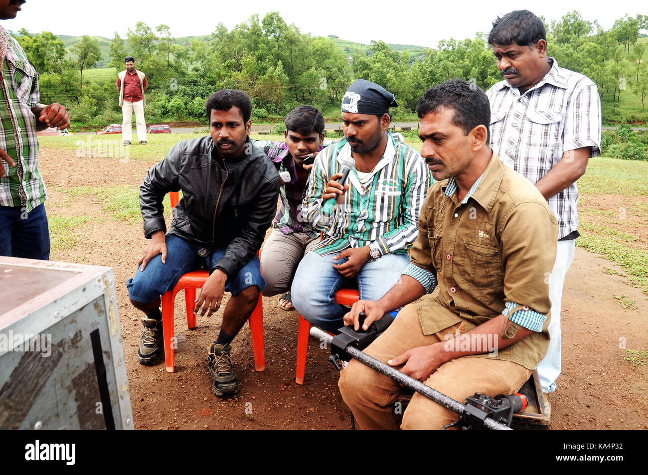 Director, staff and actors on a chair is watching a performance at ...