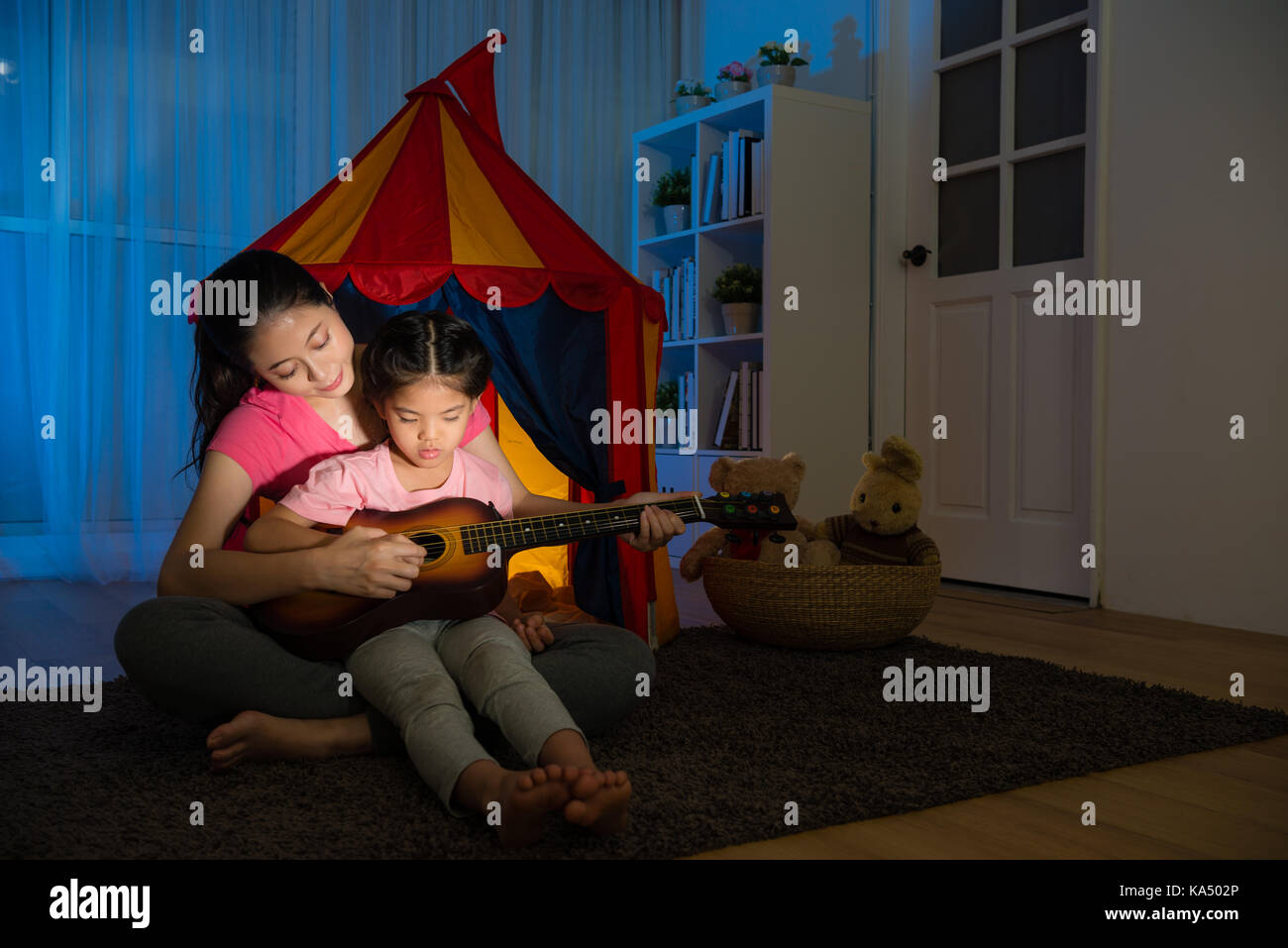 Leisurely Young Housewife Teaching Calm Beautiful Daughter Playing