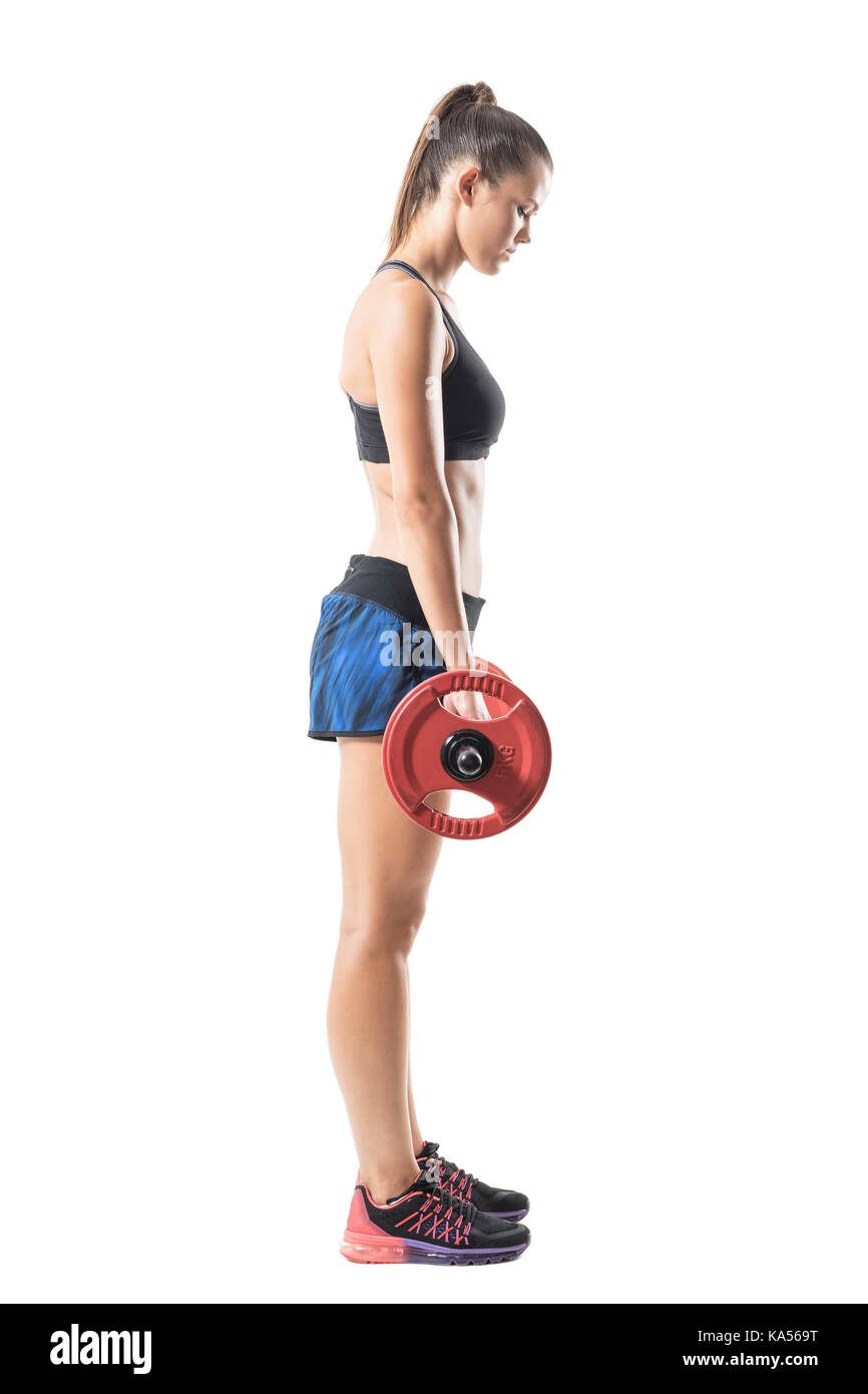 Side view of fit female athlete doing deadlift in ending extended ...