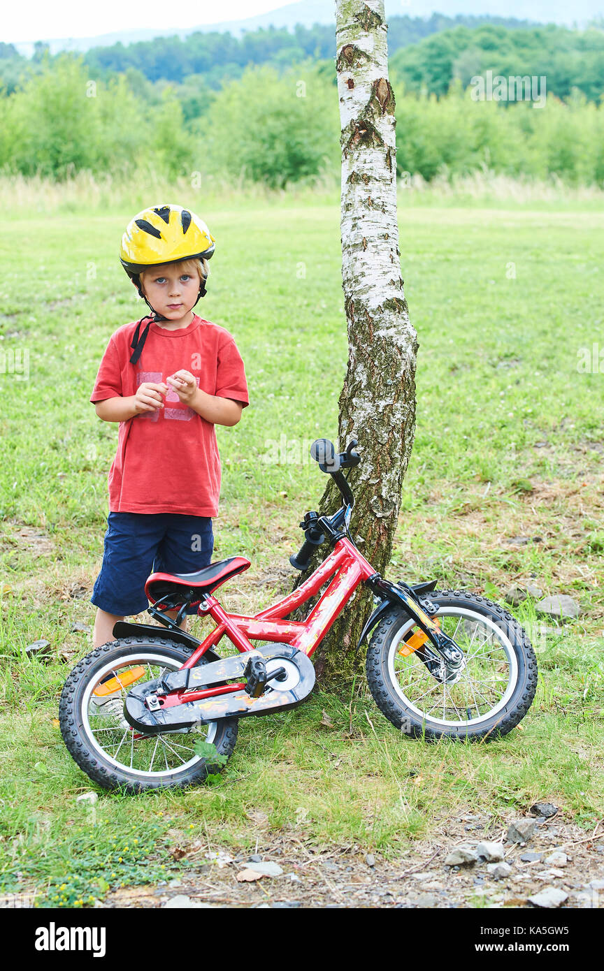 Young boy riding bicycle on a summer day at asphalt road. Bicycle path ...