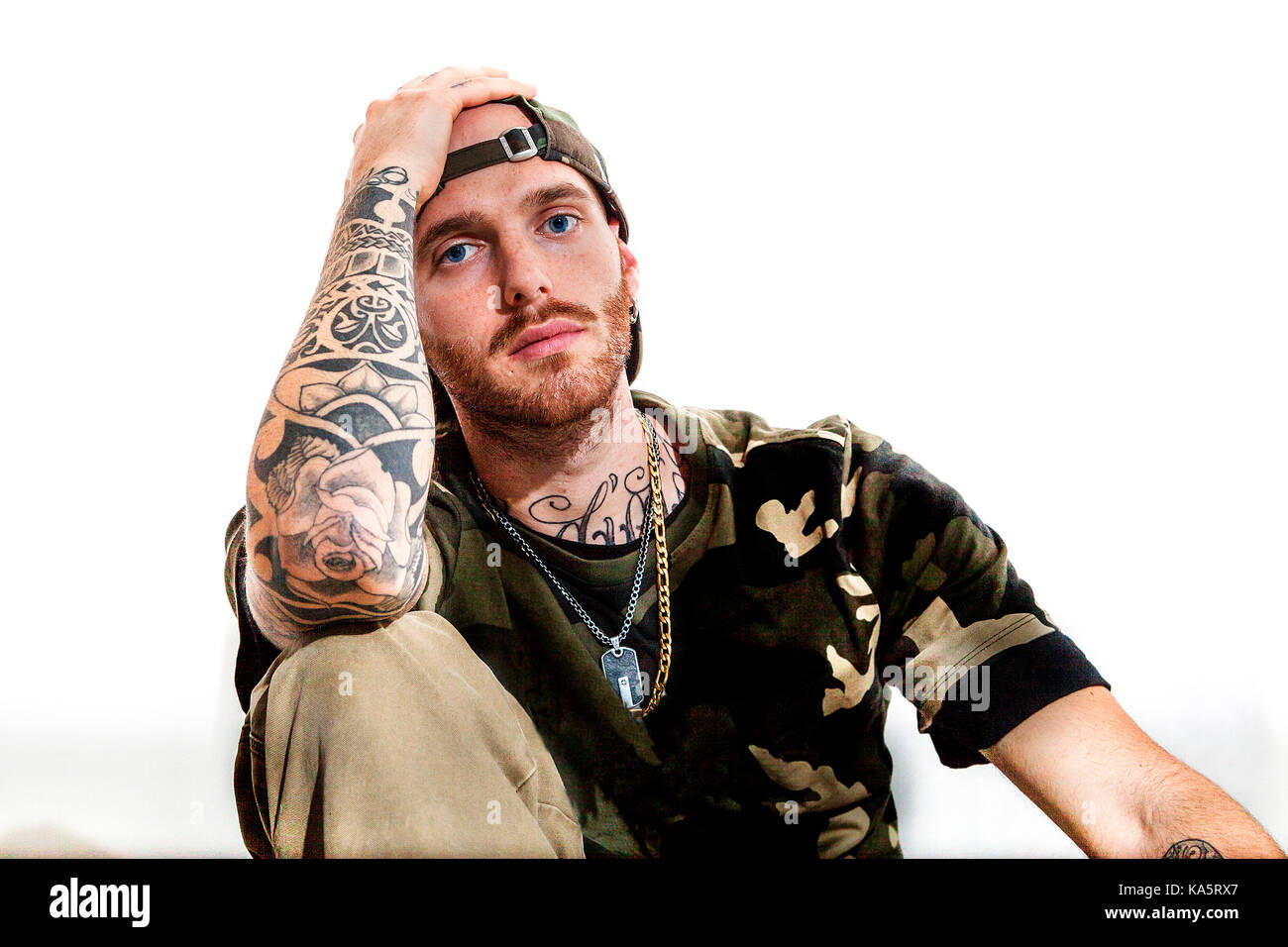 sitting tattooed rap singer posing in studio with an amplified radio on ...