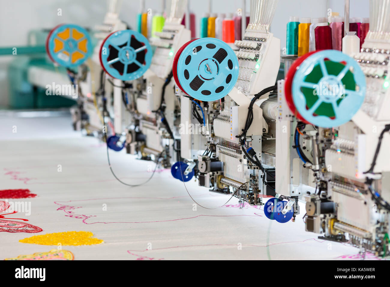 Factory sewing machine makes color pattern closeup. Textile fabric ...