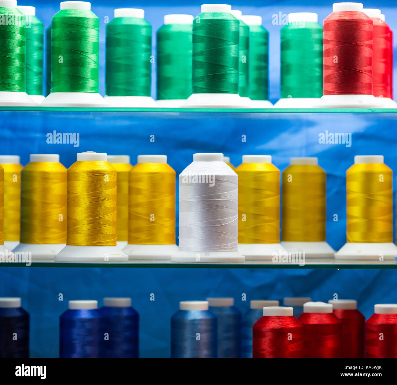 Spools of new color threads, sewing equipment. Cloth factory, weaving ...