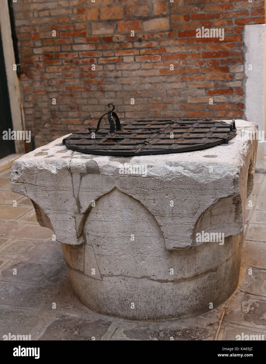very ancient stone well in a square of a European city Stock Photo - Alamy