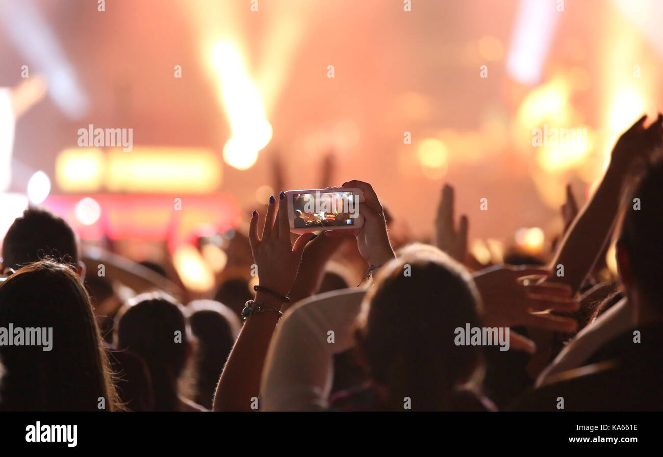 young girl takes a picture during a live concert of a rock band Stock ...
