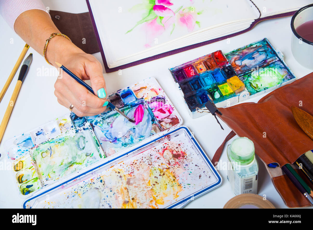 A close-up artist paints and paints in the album for drawing a thin ...