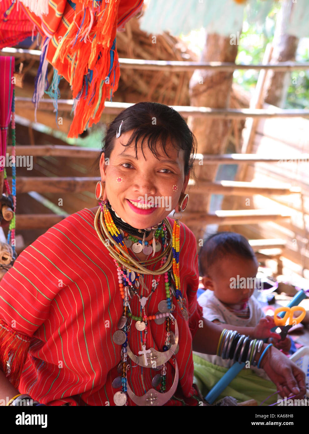 Closeup portrait of Young woman with a child Akha pagan tribe. Young ...