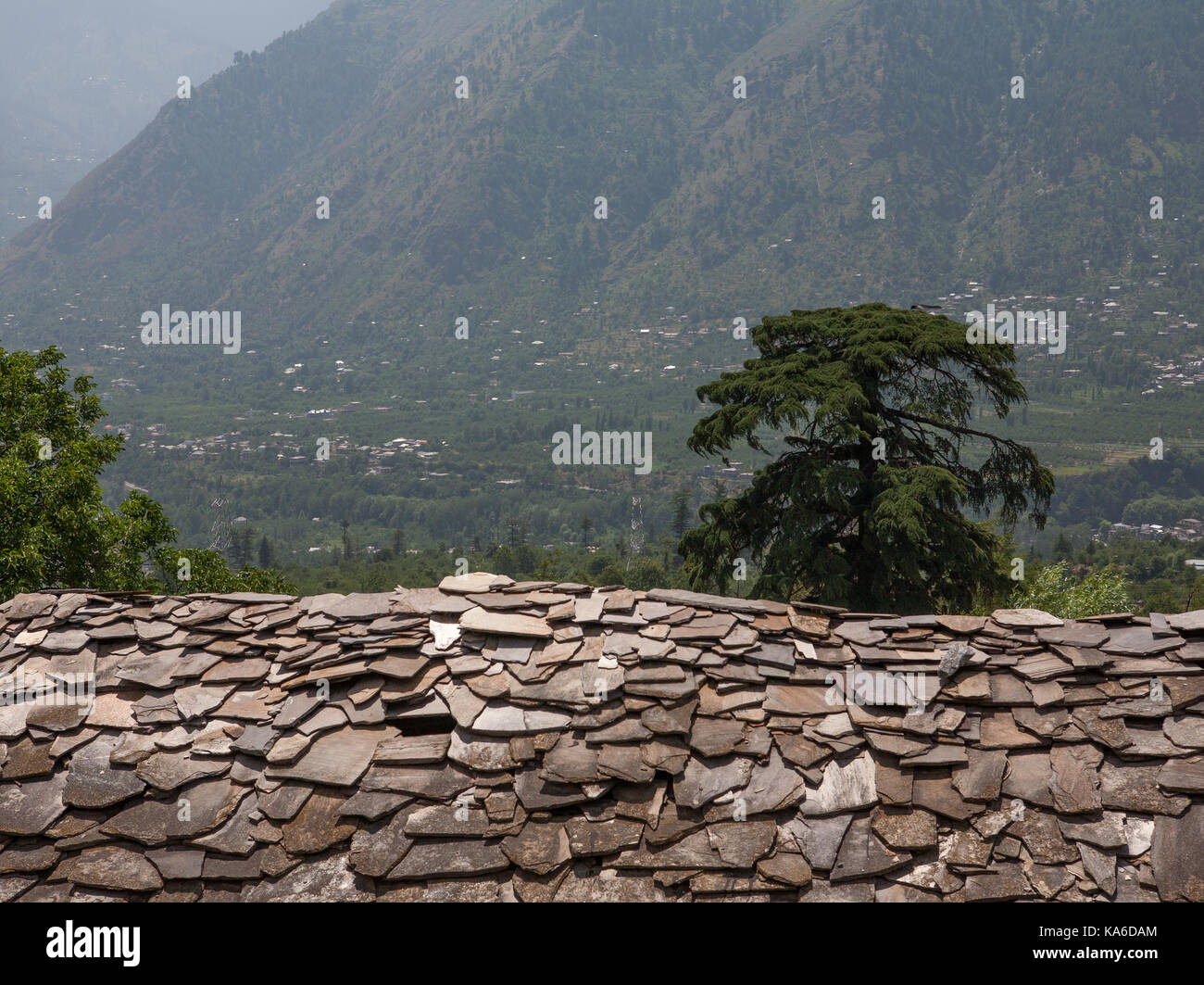 At home on the slopes of the Himalayas. Traditional roofs of flat ...