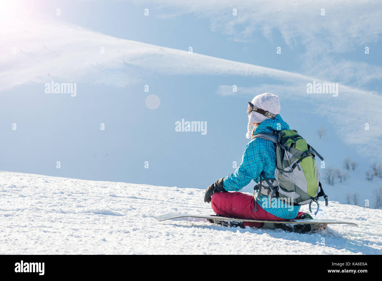 Young woman with snowboard sitting on the slope of hill Stock Photo - Alamy