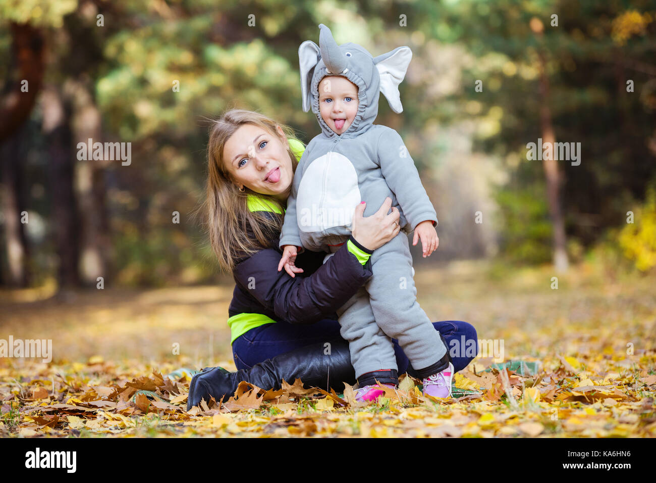 Young woman and daughter dressed in elephant costume poking out their ...
