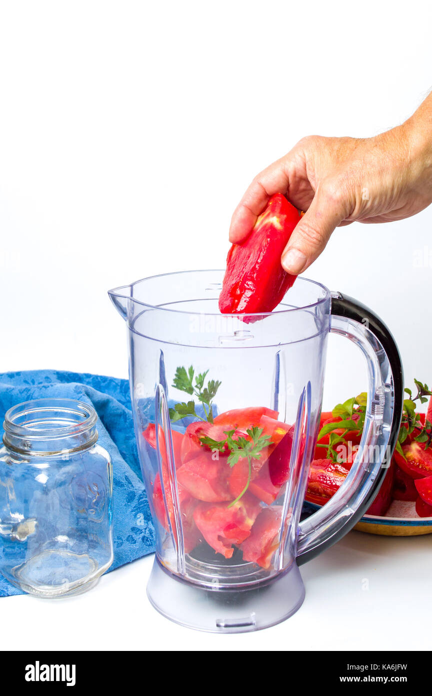 Man adding tomato slices in a blender for making a smoothie Stock Photo ...