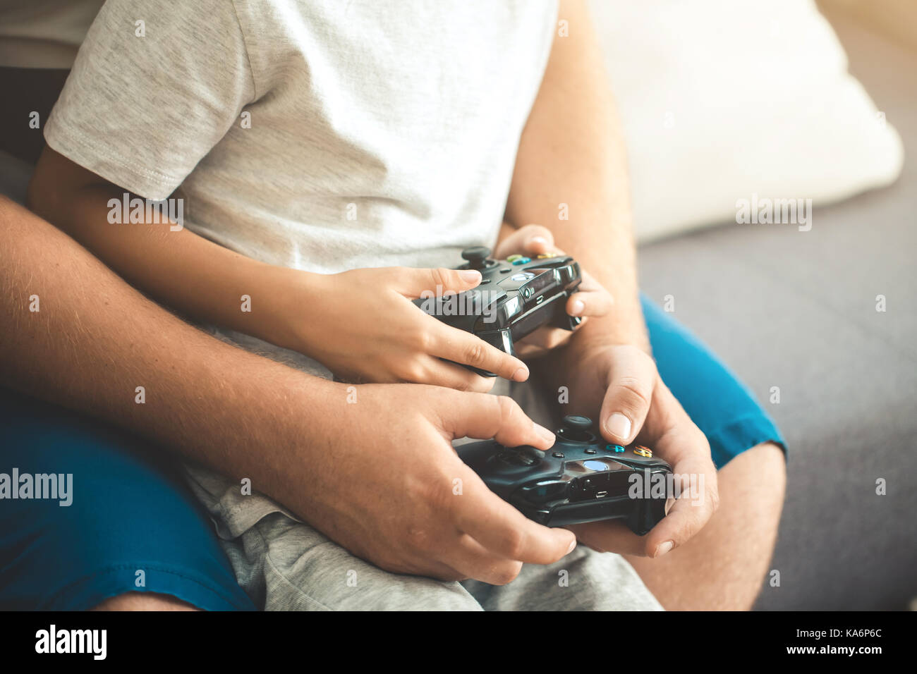 Father and son holding a joystick controllers while playing a video ...