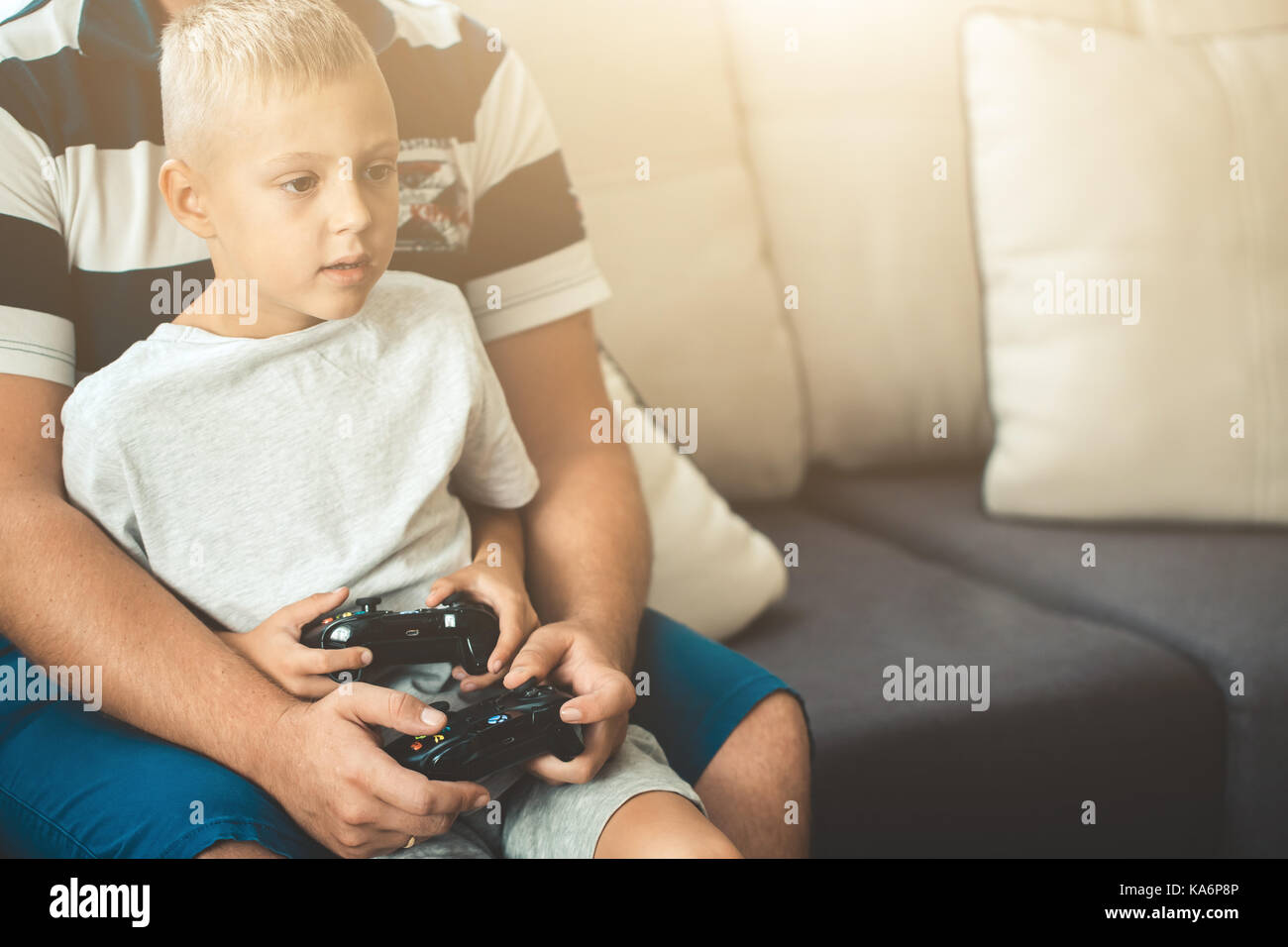 Father and son holding a joystick controllers while playing a video ...