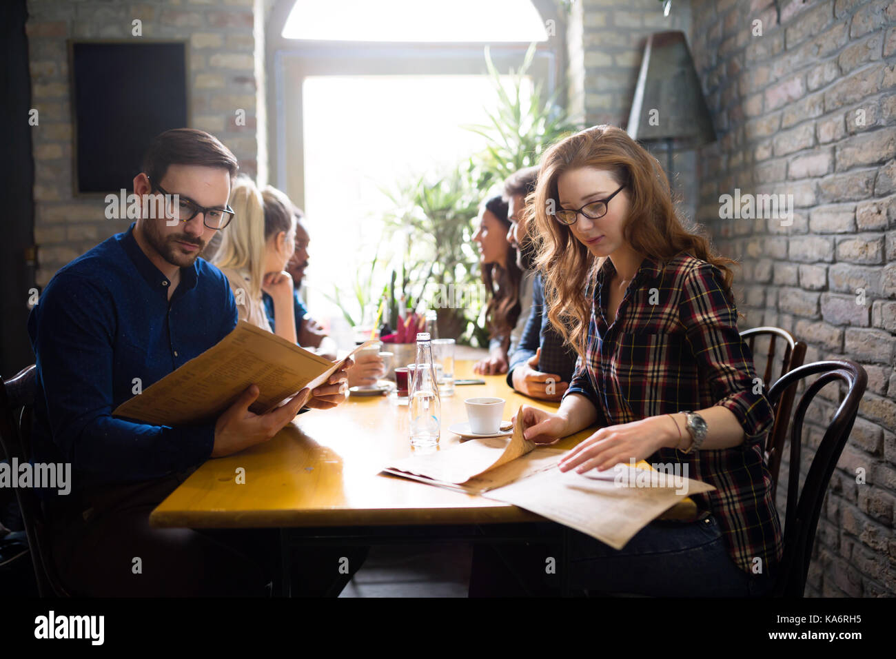Colleagues from work socializing in restaurant and eating togeth Stock ...