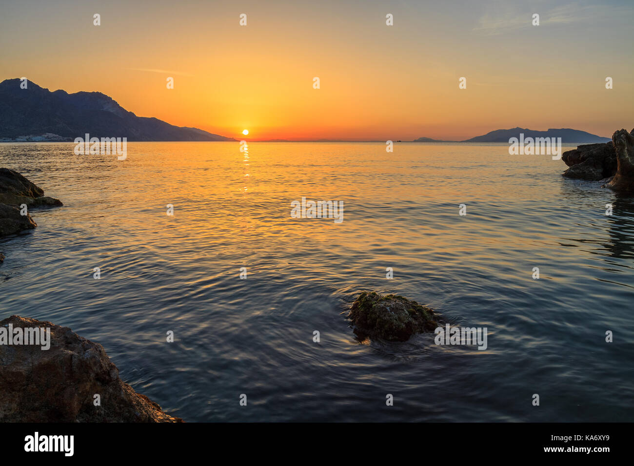 Beautiful sunrise landscape with sea, rock and mountains Stock Photo ...