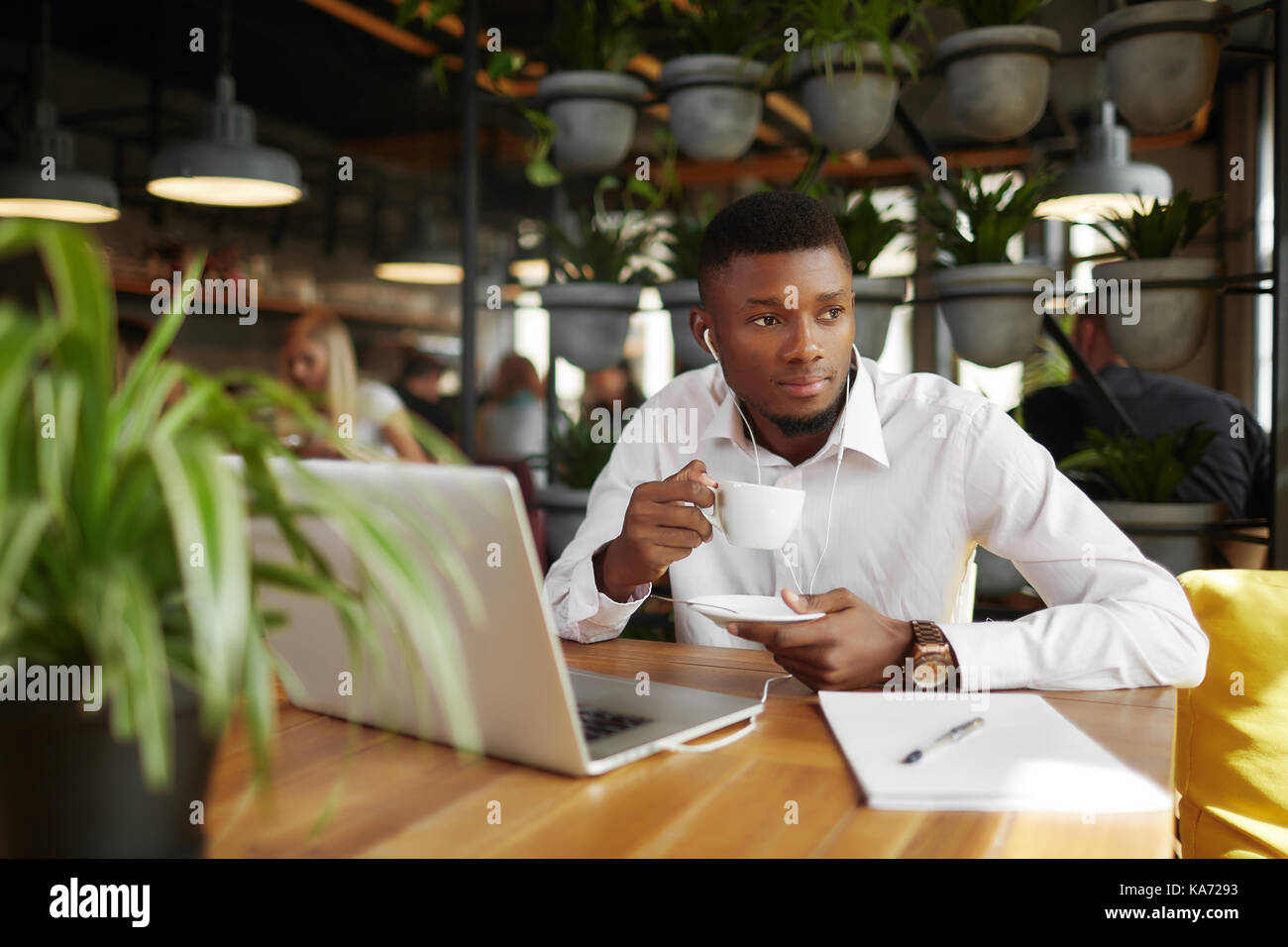 Businessman drinking coffee in cafe resting after work with laptop ...