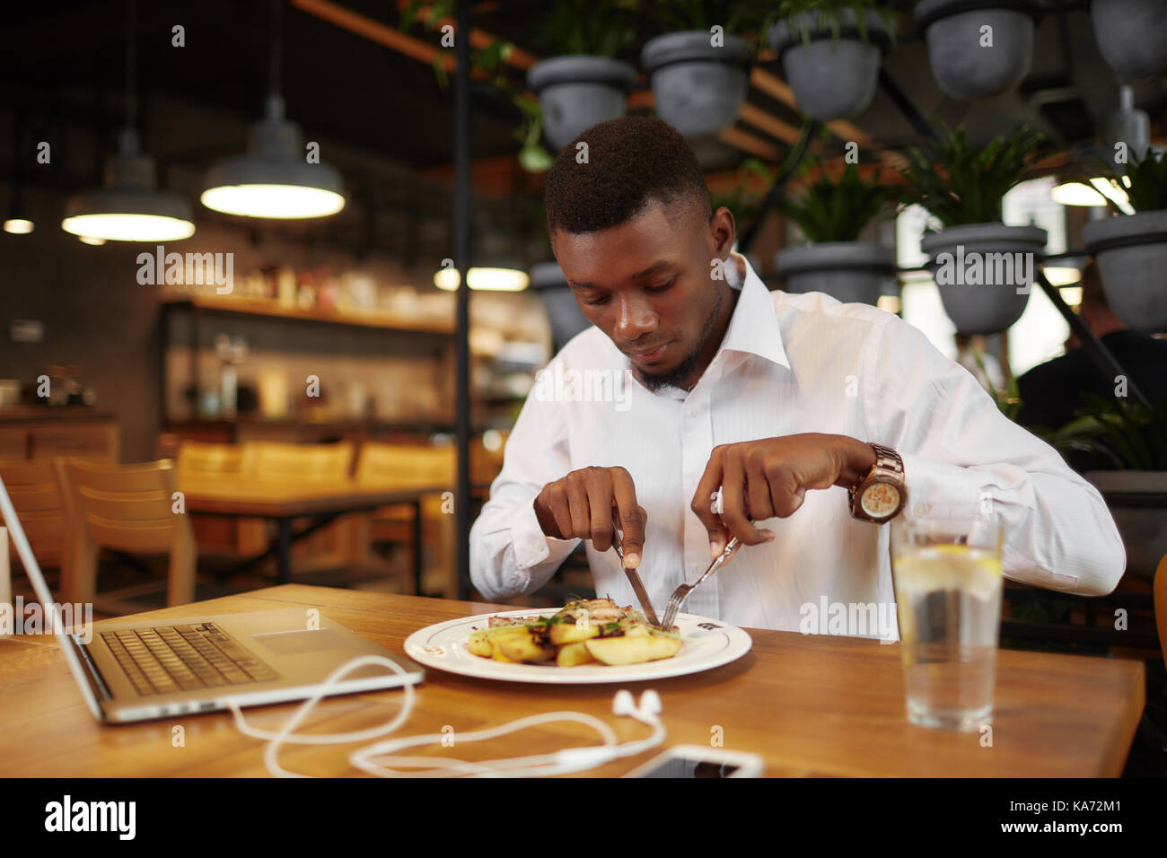 Aafrican man have dinner at cafe after work with laptop Stock Photo - Alamy