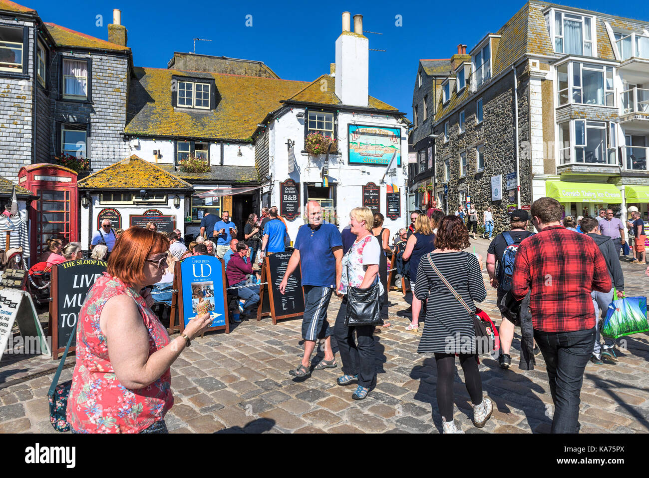 St Ives - holidaymakers relaxing at the historic Sloop Inn pub on the ...